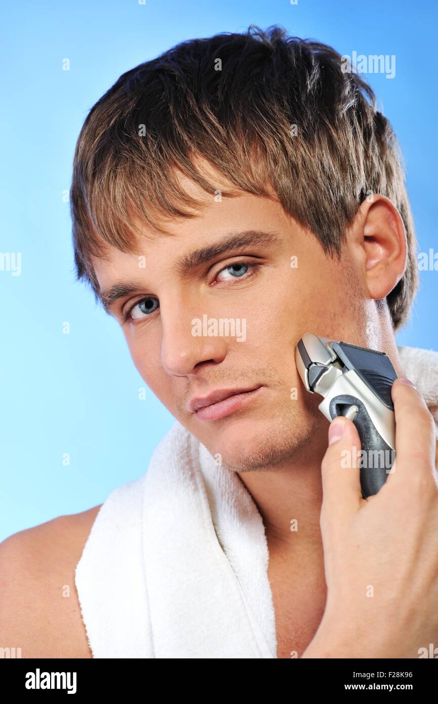 Handsome young man shaving Stock Photo - Alamy