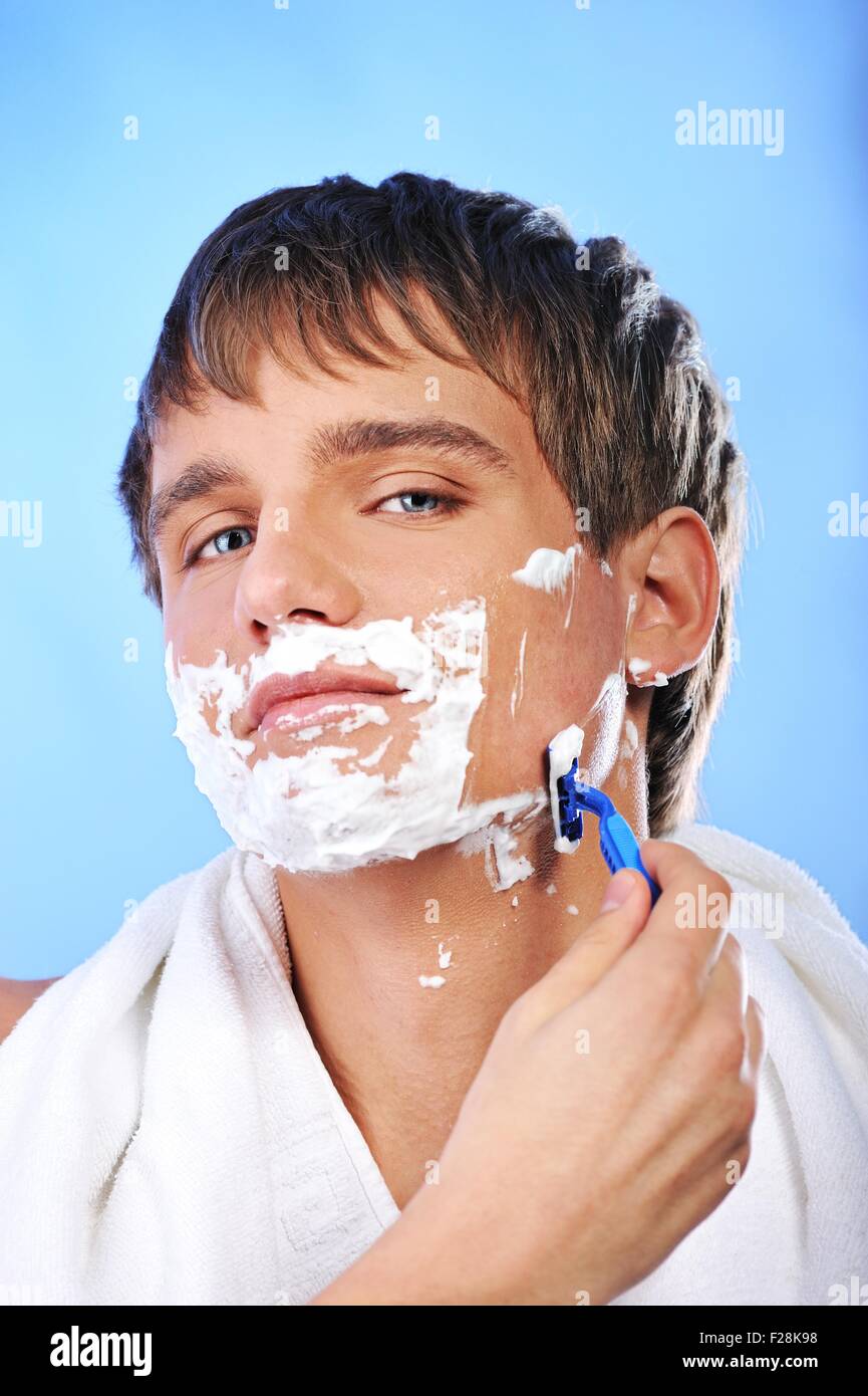 Handsome young man shaving Stock Photo - Alamy