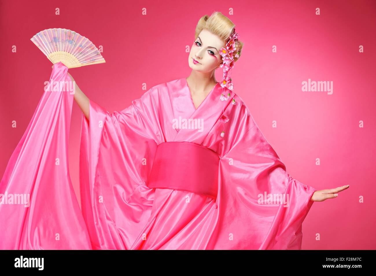 Beautiful geisha dancing with a fan Stock Photo - Alamy