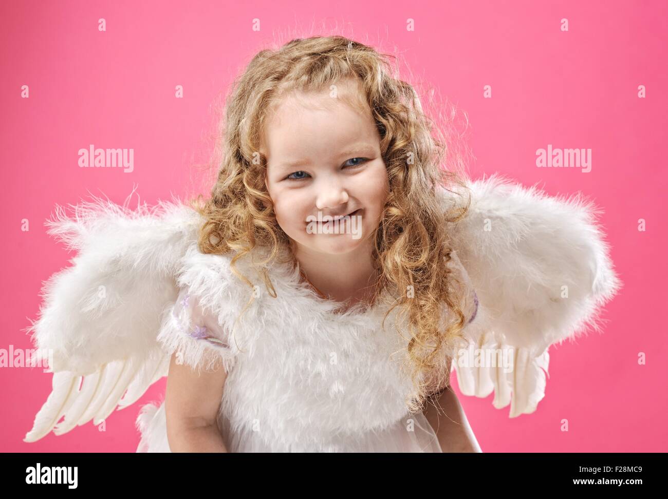 Beautiful little angel girl isolated on pink background Stock Photo - Alamy