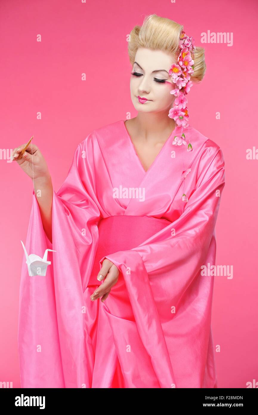 Beautiful geisha holding origami bird Stock Photo - Alamy