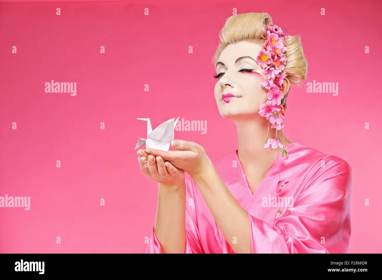 Beautiful geisha holding origami bird Stock Photo - Alamy