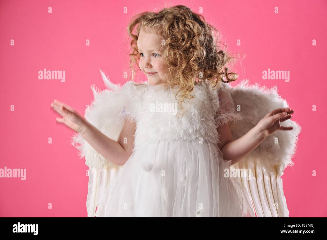 Beautiful little angel girl isolated on pink background Stock Photo - Alamy