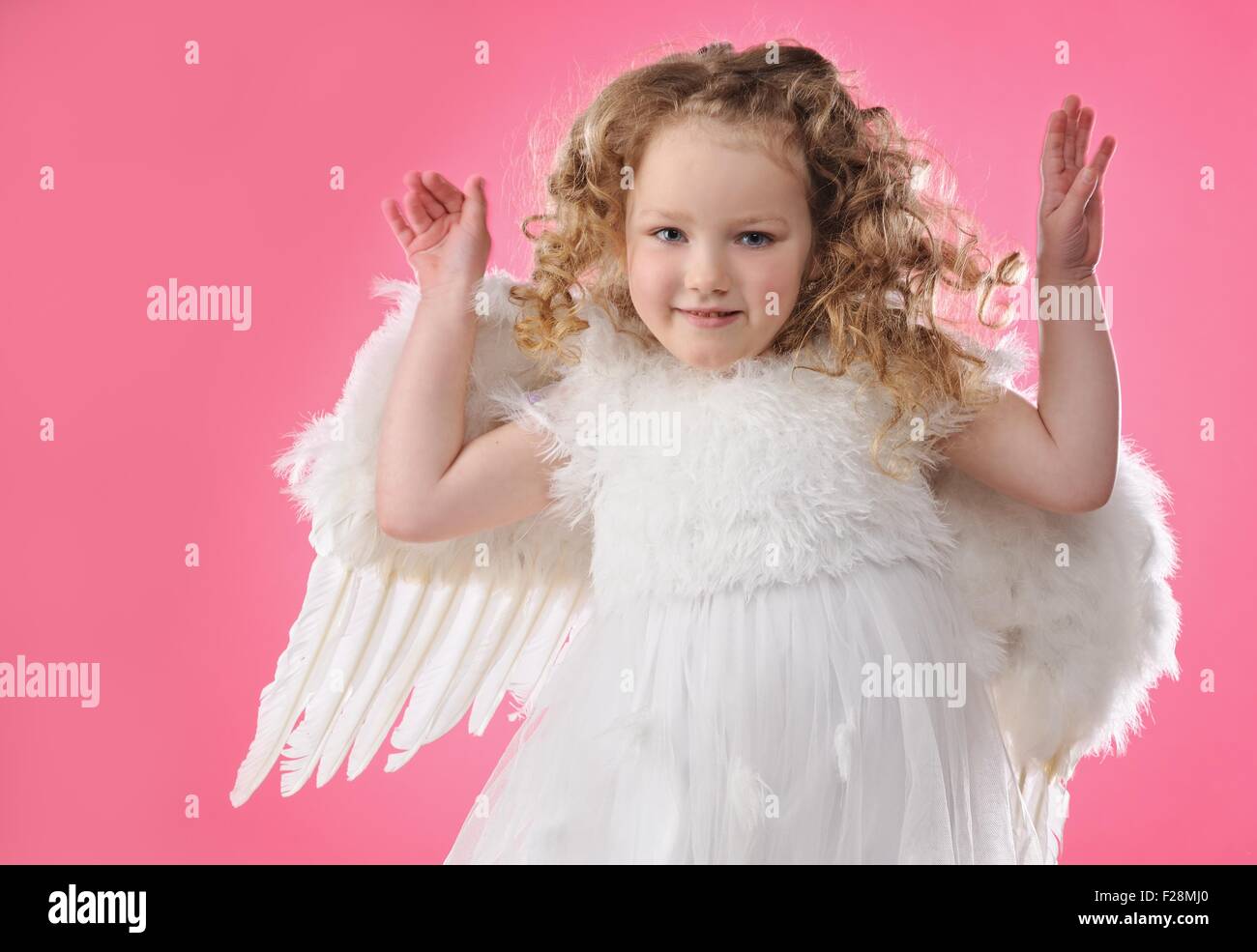 Beautiful little angel girl isolated on pink background Stock Photo - Alamy