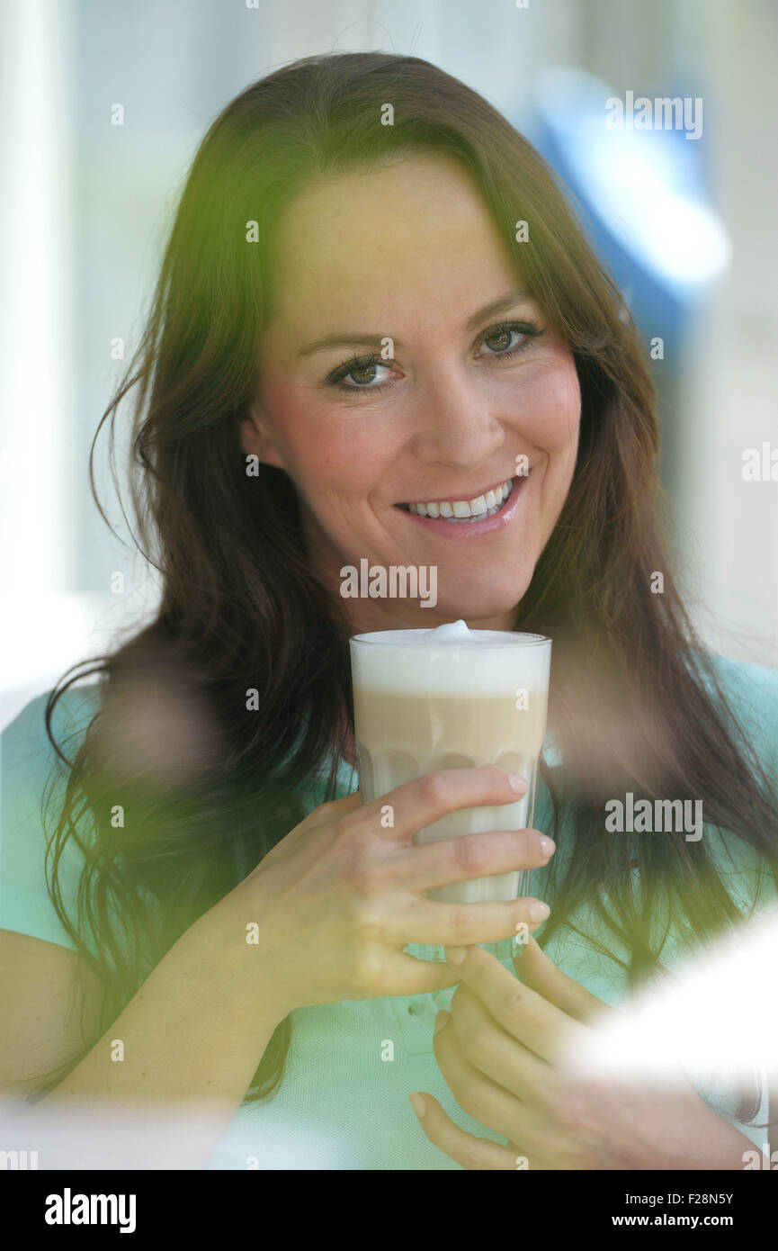 A woman is drinking a latte macchiato Stock Photo - Alamy