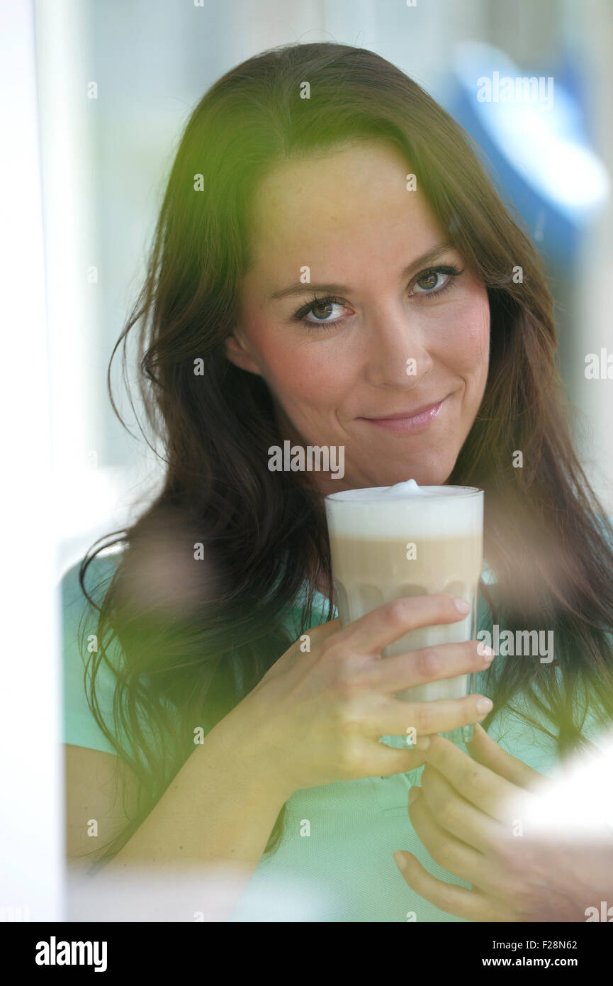 A woman is drinking a latte macchiato Stock Photo - Alamy