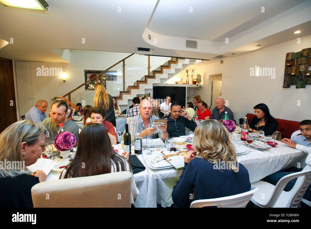 family sitting around a table set for a Jewish Festive meal on Passover ...