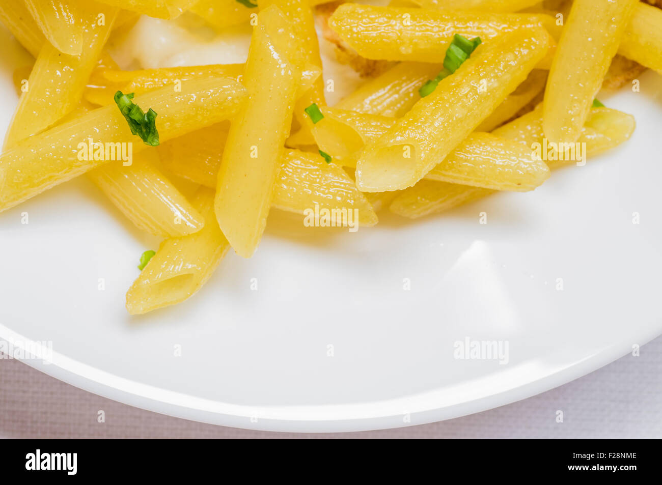 Fried penne pasta on a white plate closeup top view Stock Photo - Alamy