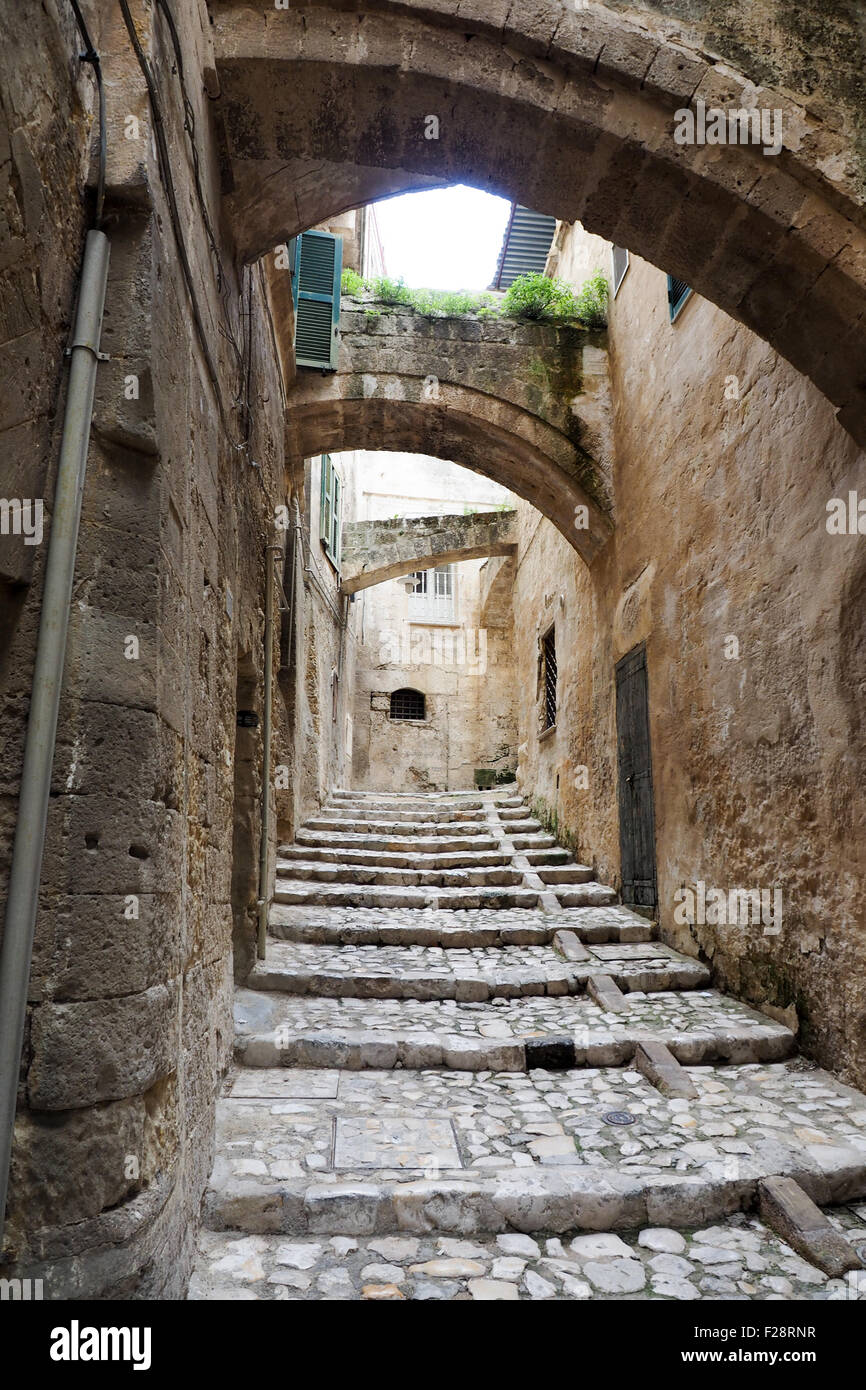 Stone steps between two stone buildings braced by stone arches Stock ...