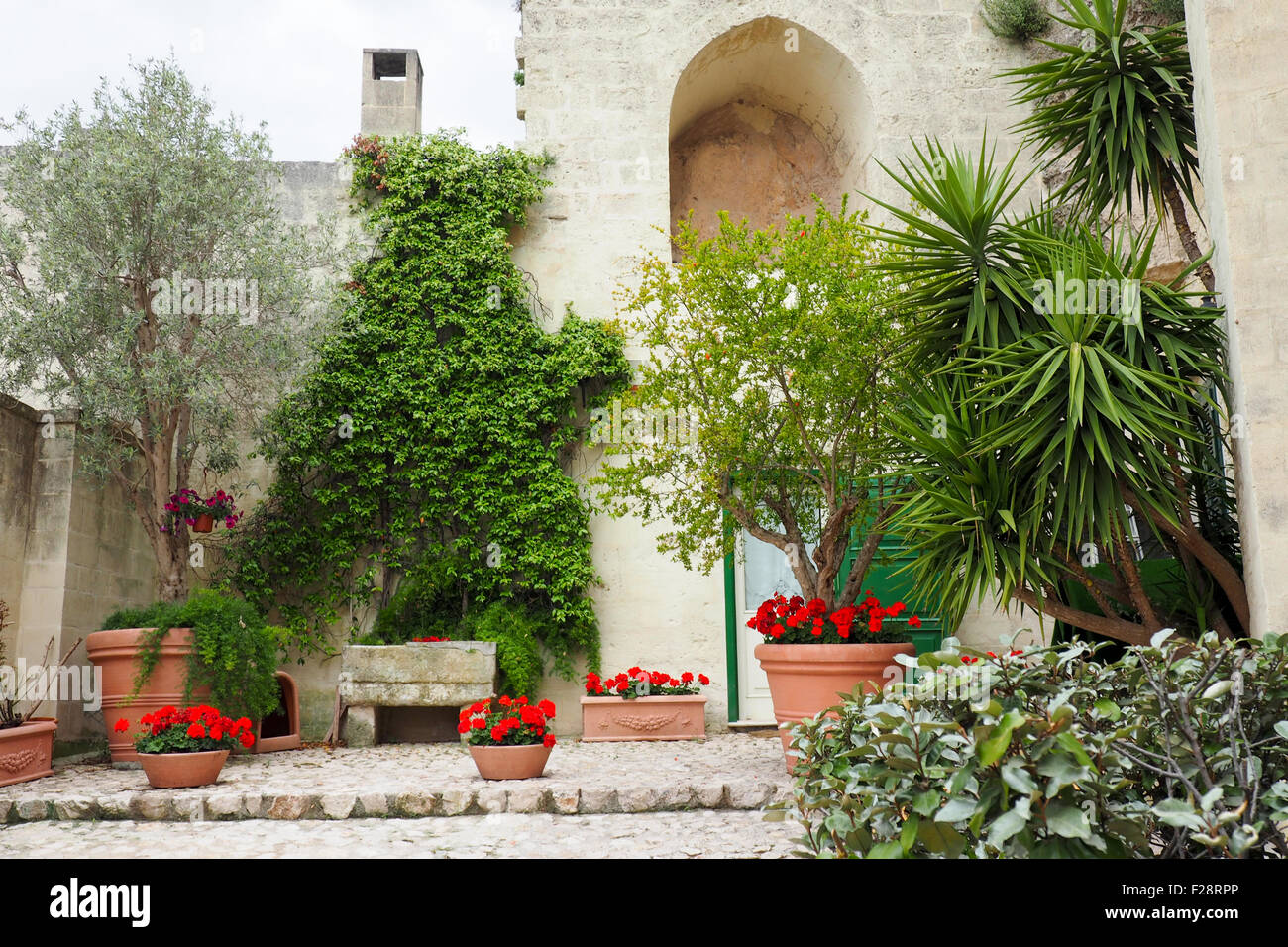 A courtyard garden with red flowers Stock Photo - Alamy
