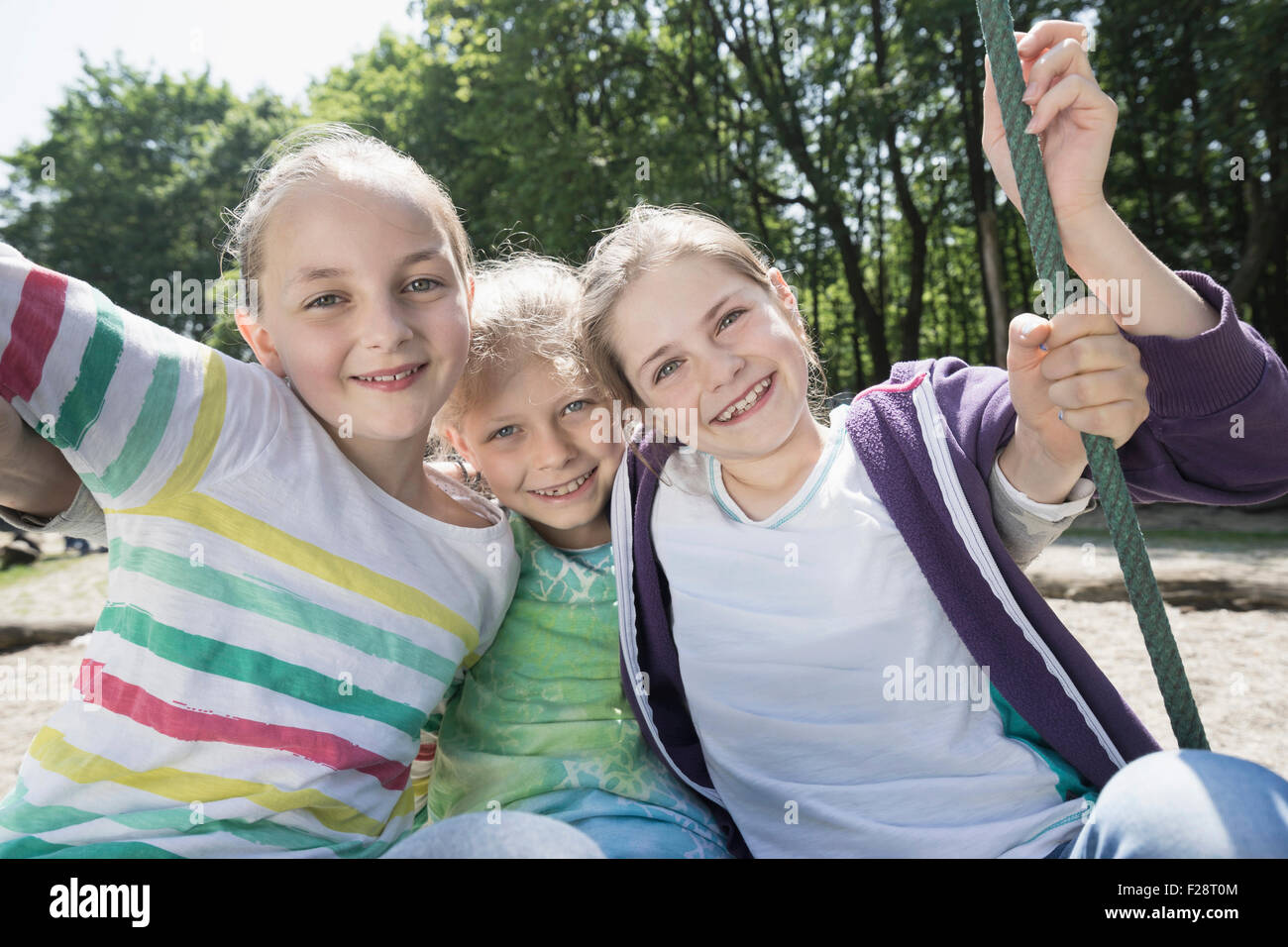 Girls swinging on a swing in playground, Munich, Bavaria, Germany Stock ...