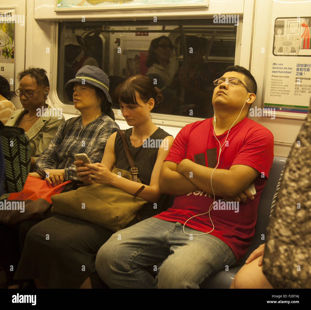 People riding the subway along 42nd St.on the #7 train in Manhattan ...
