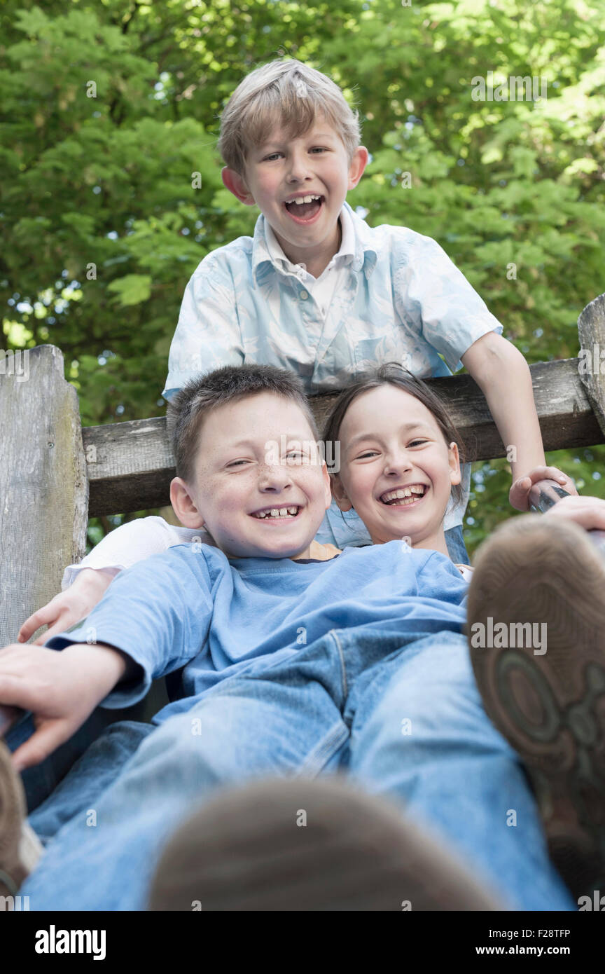Three friends having fun on slide in playground, Munich, Bavaria ...