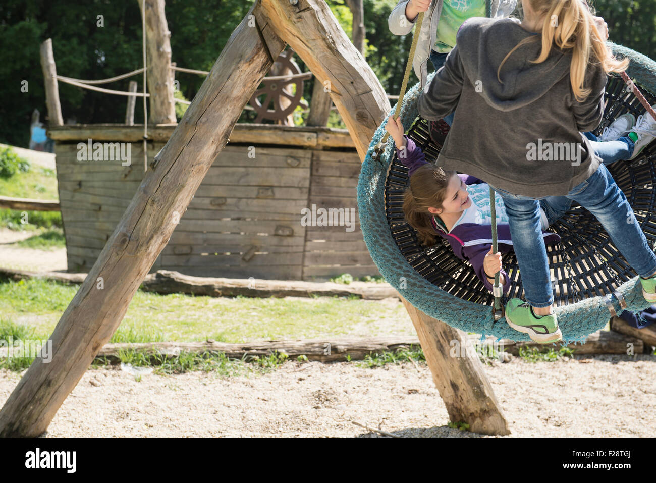 Two girls swinging on a swing in playground, Munich, Bavaria, Germany ...