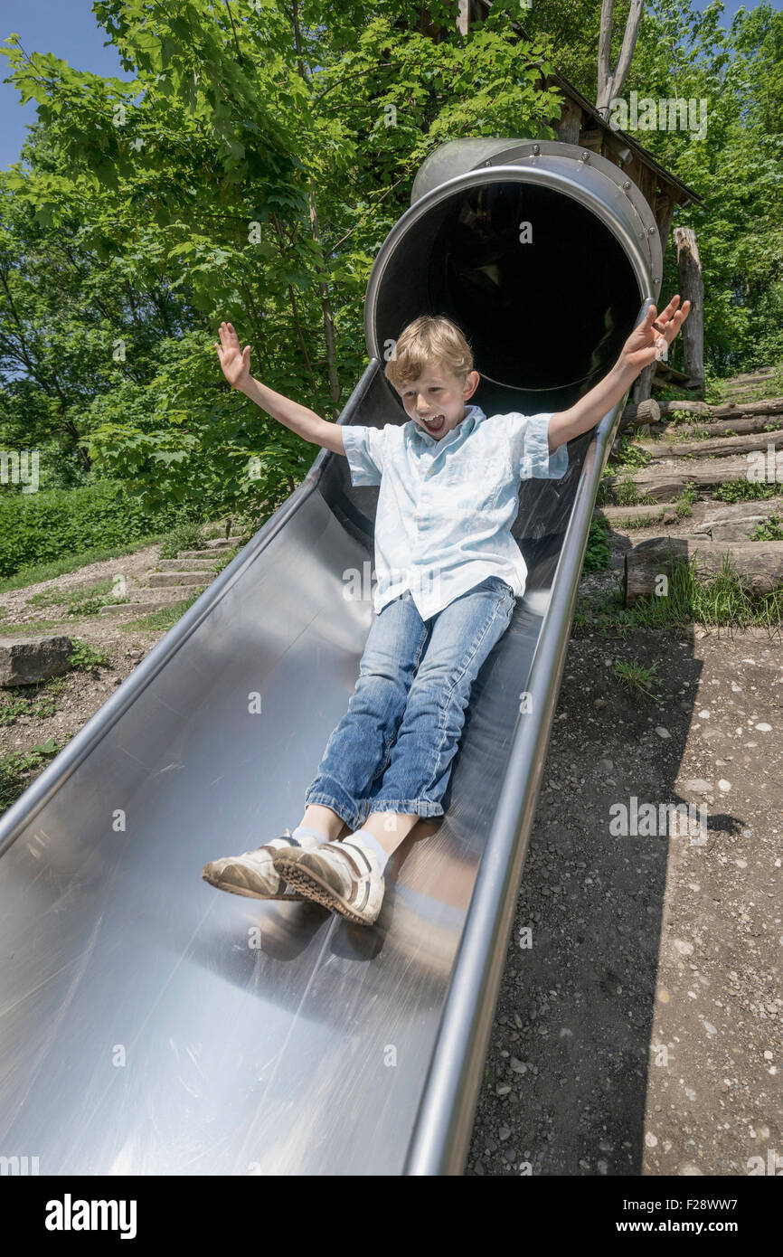 Boy sliding on slide in playground, Munich, Bavaria, Germany Stock ...