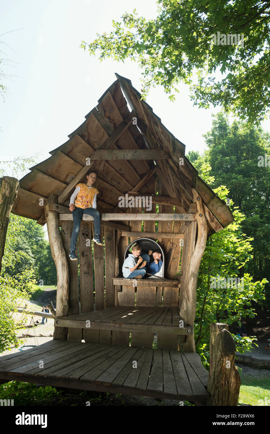 Two boys and a girl on a cottage in the adventure playground, Munich ...