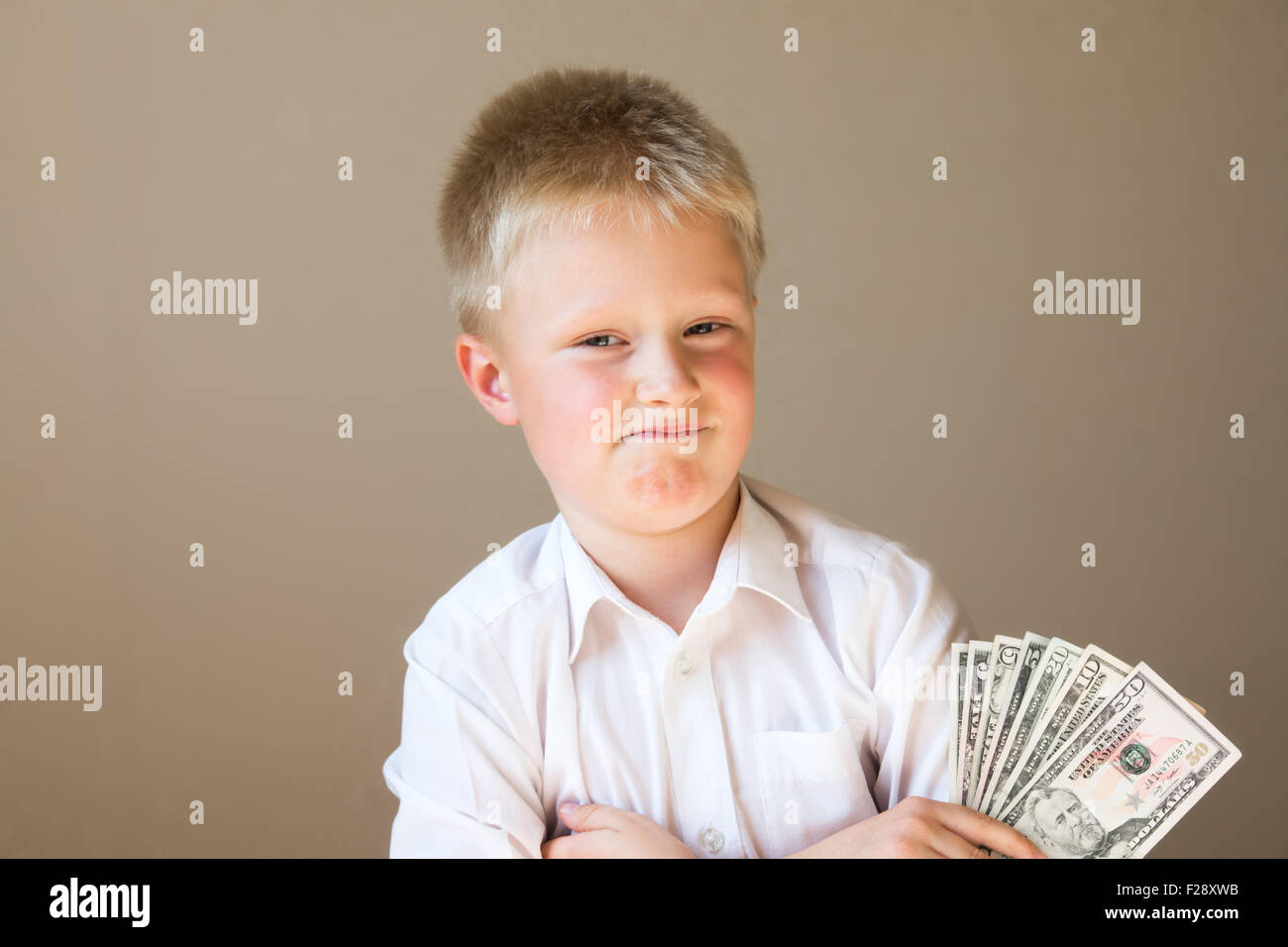 Happy smiling funny child with money (dollars) in hand on grey ...