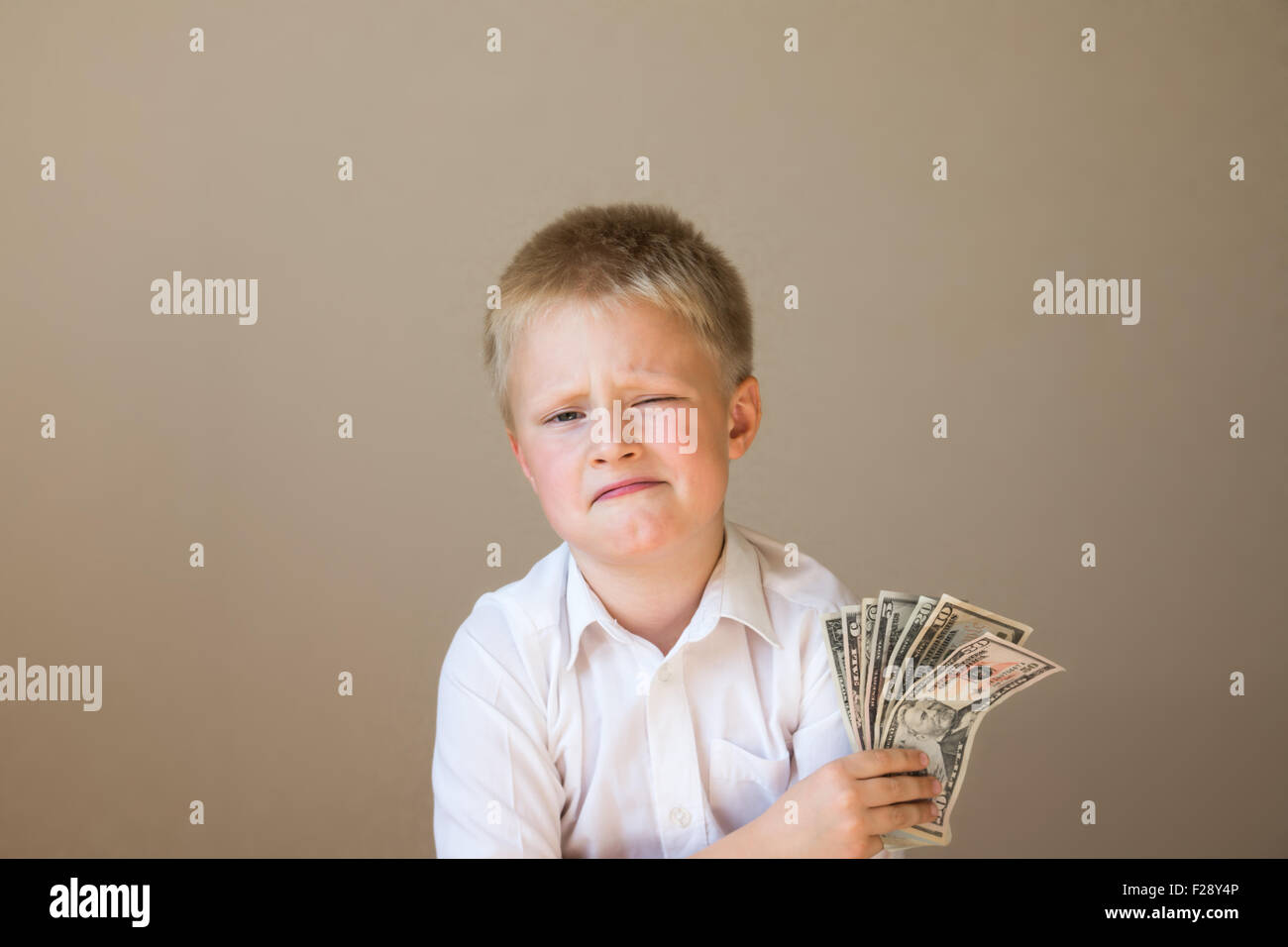 Happy smiling funny child with money (dollars) in hand on gray ...