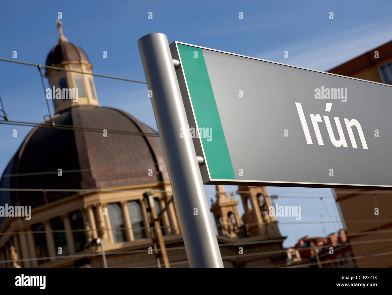City name signpost at railway station with out of focus church on ...