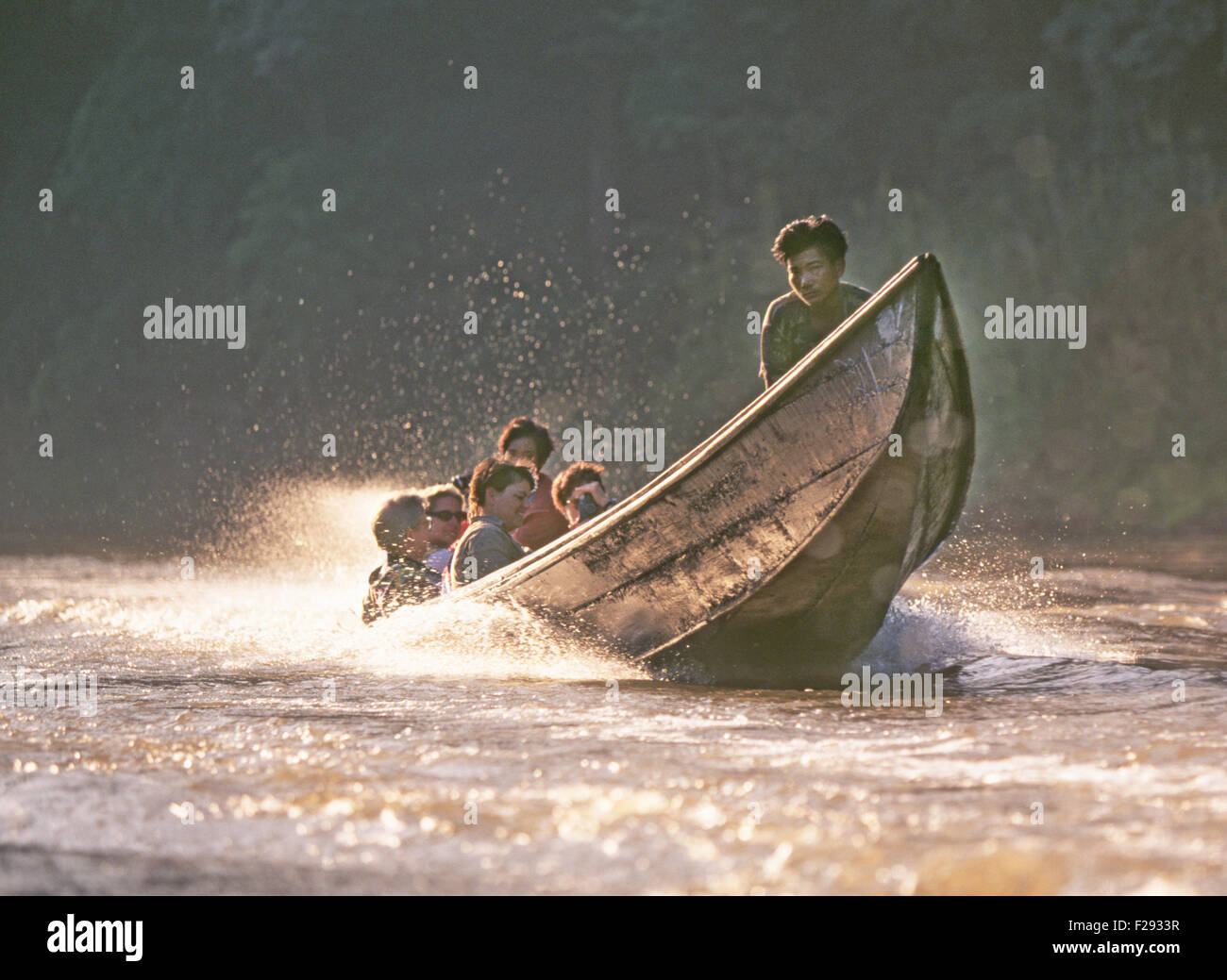 Thai boatmen carry tourists up the Ping River in a tiger-tailed boat ...