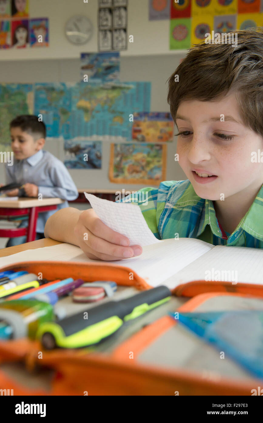 Schoolboy reading a message in classroom, Munich, Bavaria, Germany ...