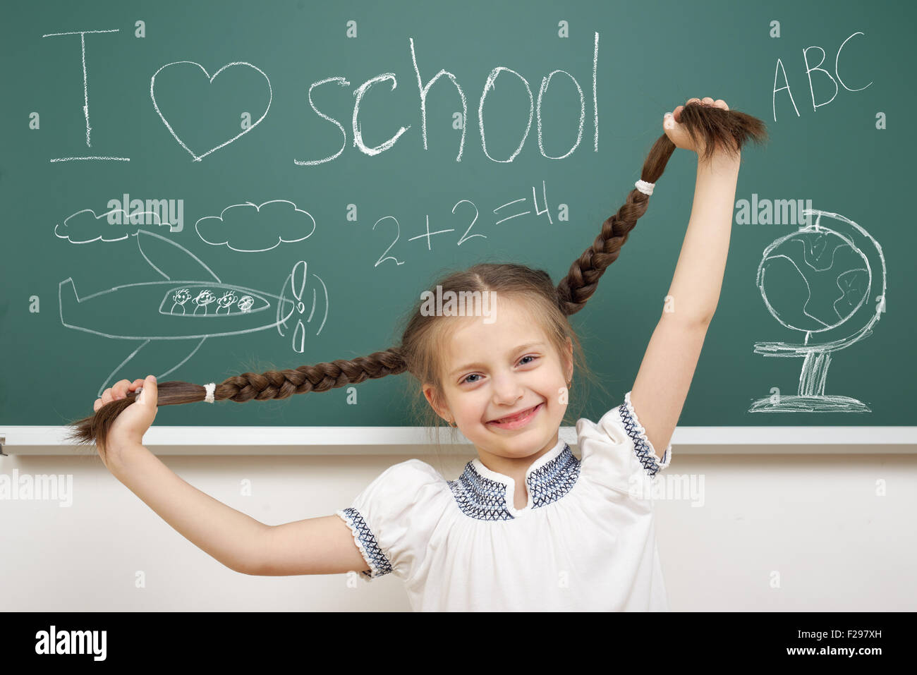 girl with pigtail drawing object on school board Stock Photo - Alamy