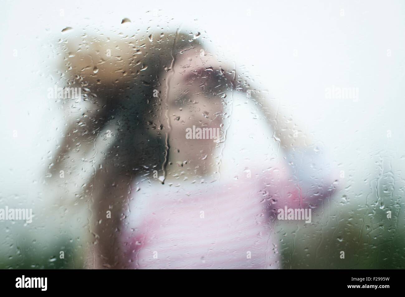 Woman looking through window rain hi-res stock photography and images ...