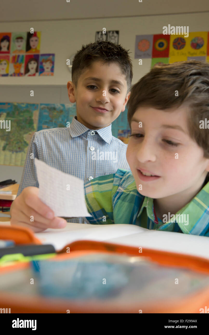 schoolboys reading a message in classroom, Munich, Bavaria, Germany ...