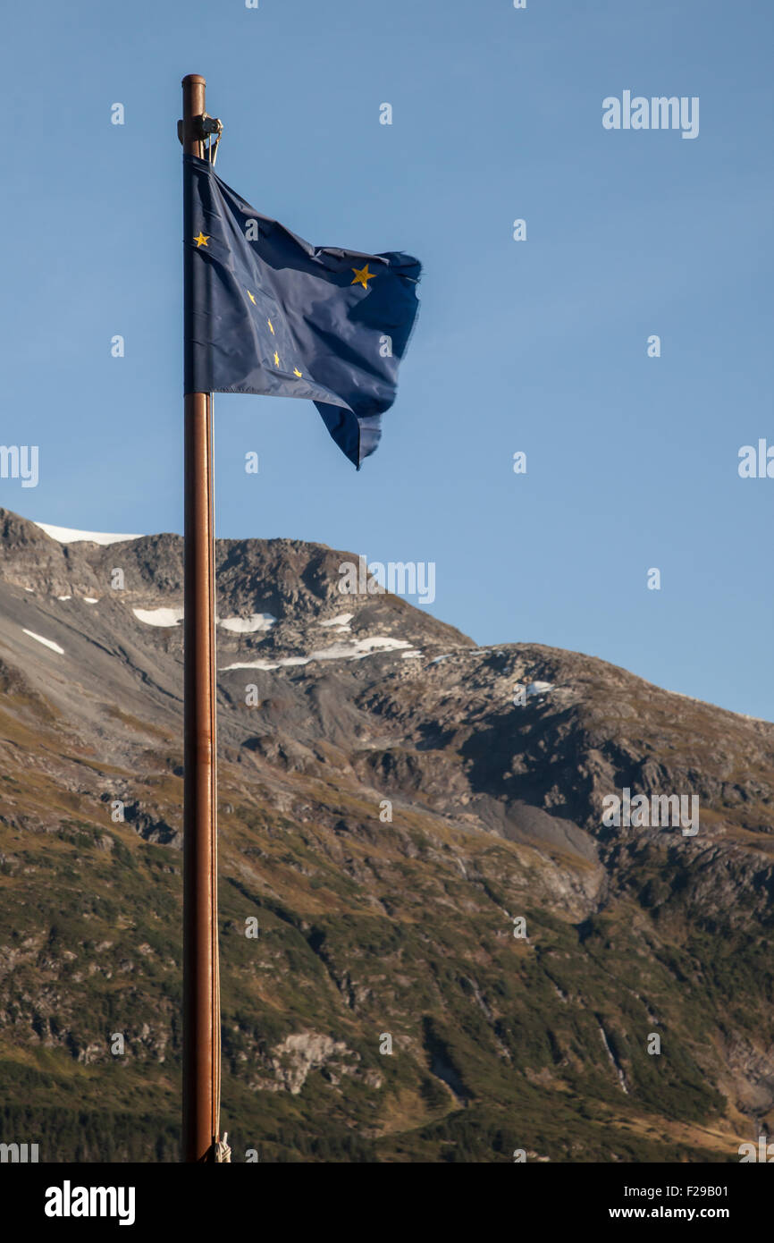 Alaskan state flag with mountains in background Stock Photo - Alamy