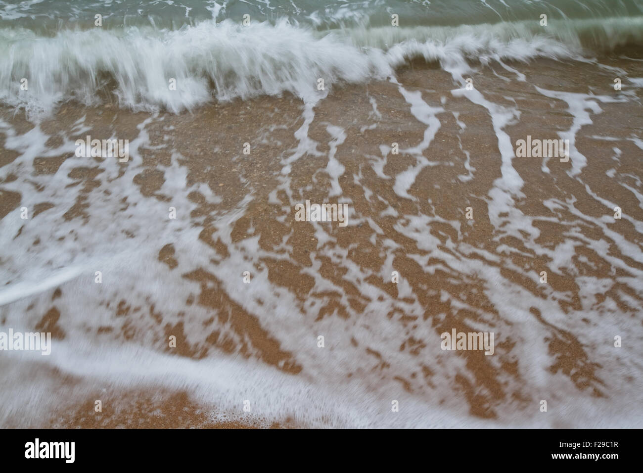 Sea wave over sand Stock Photo - Alamy
