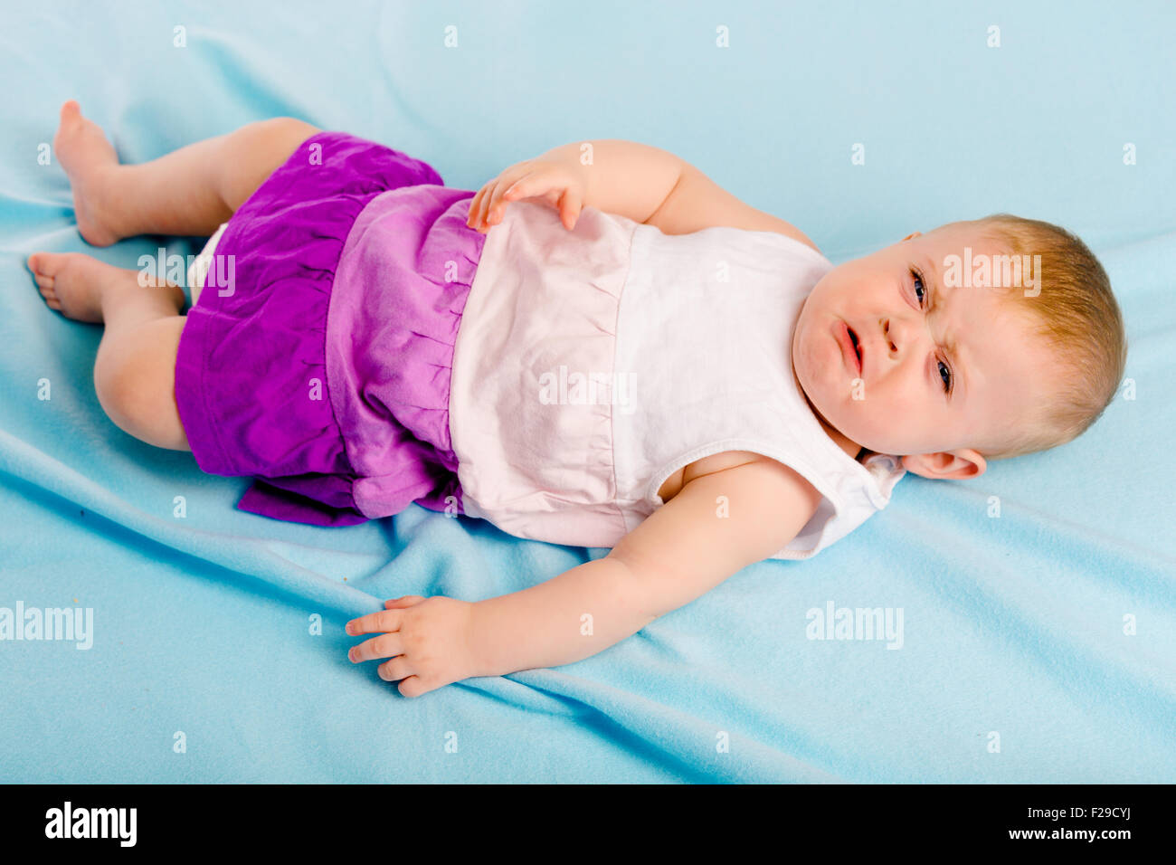 Baby girl crying lying on the back Stock Photo - Alamy