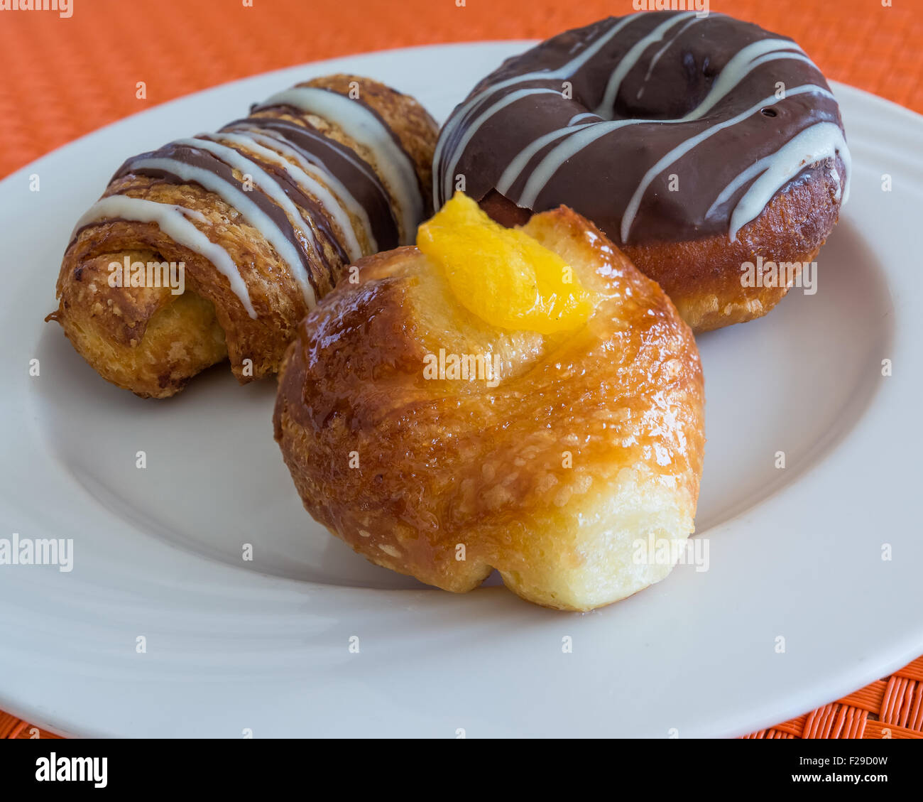 In the pictured three pastries served on a white plate Stock Photo - Alamy