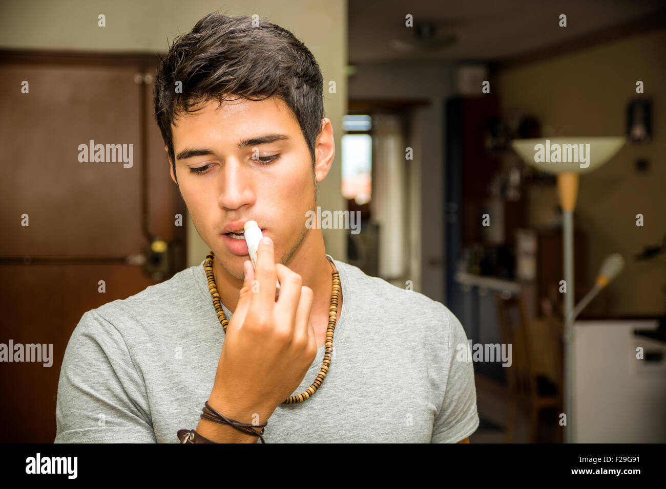 Close up Handsome Young Man Applying Lip Balm with a Serious Facial ...