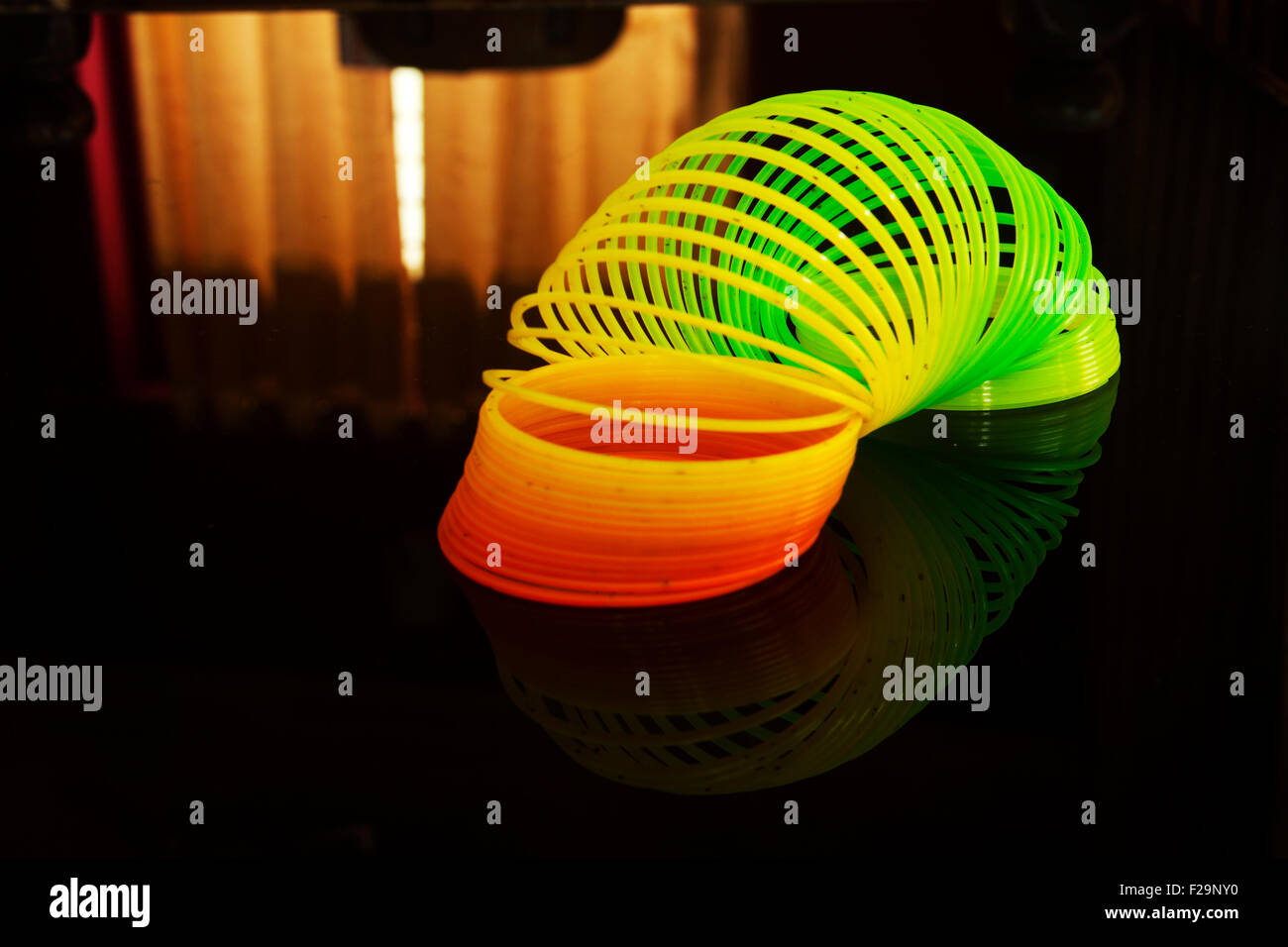 Rainbow coloured slinky toy made of a plastic wire spiral coil which ...