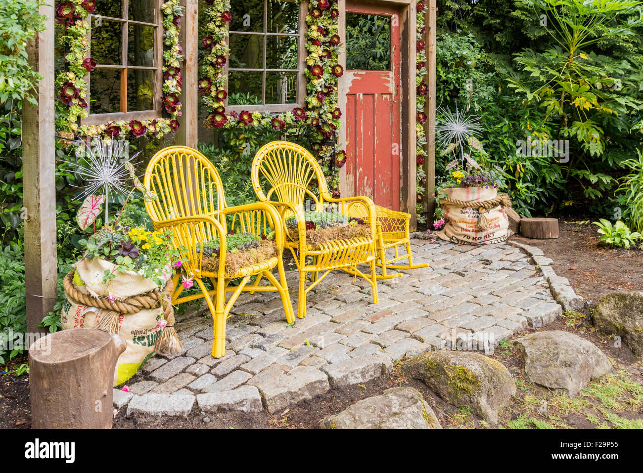 Garden display with rattan chairs as planters Stock Photo - Alamy