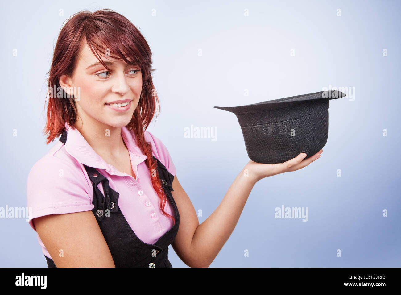 Creative magician cute woman holding a surprise hat Stock Photo - Alamy