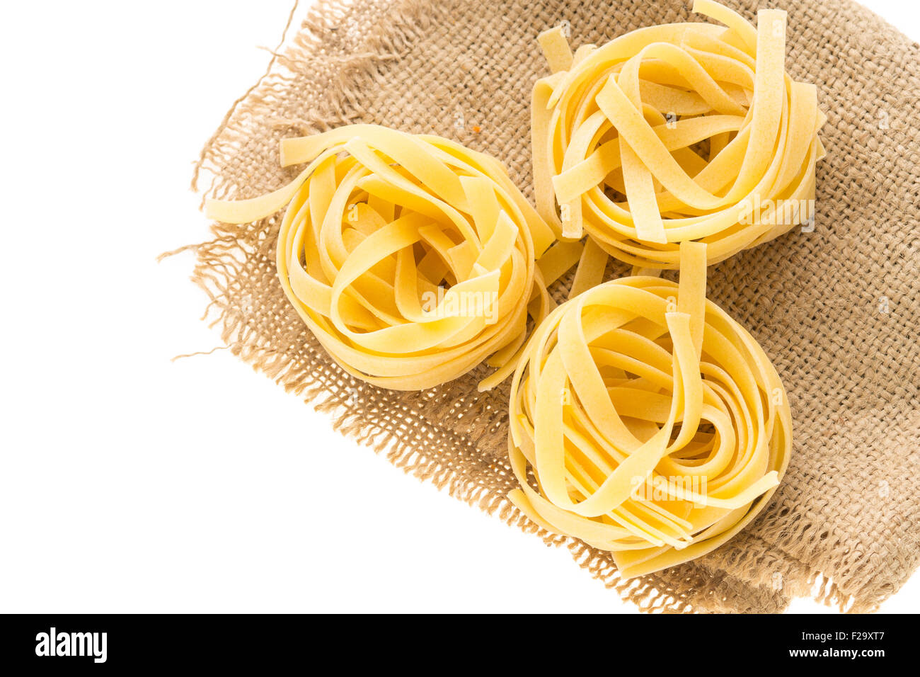 Italian pasta noodle nest on piece of sack on white background Stock ...