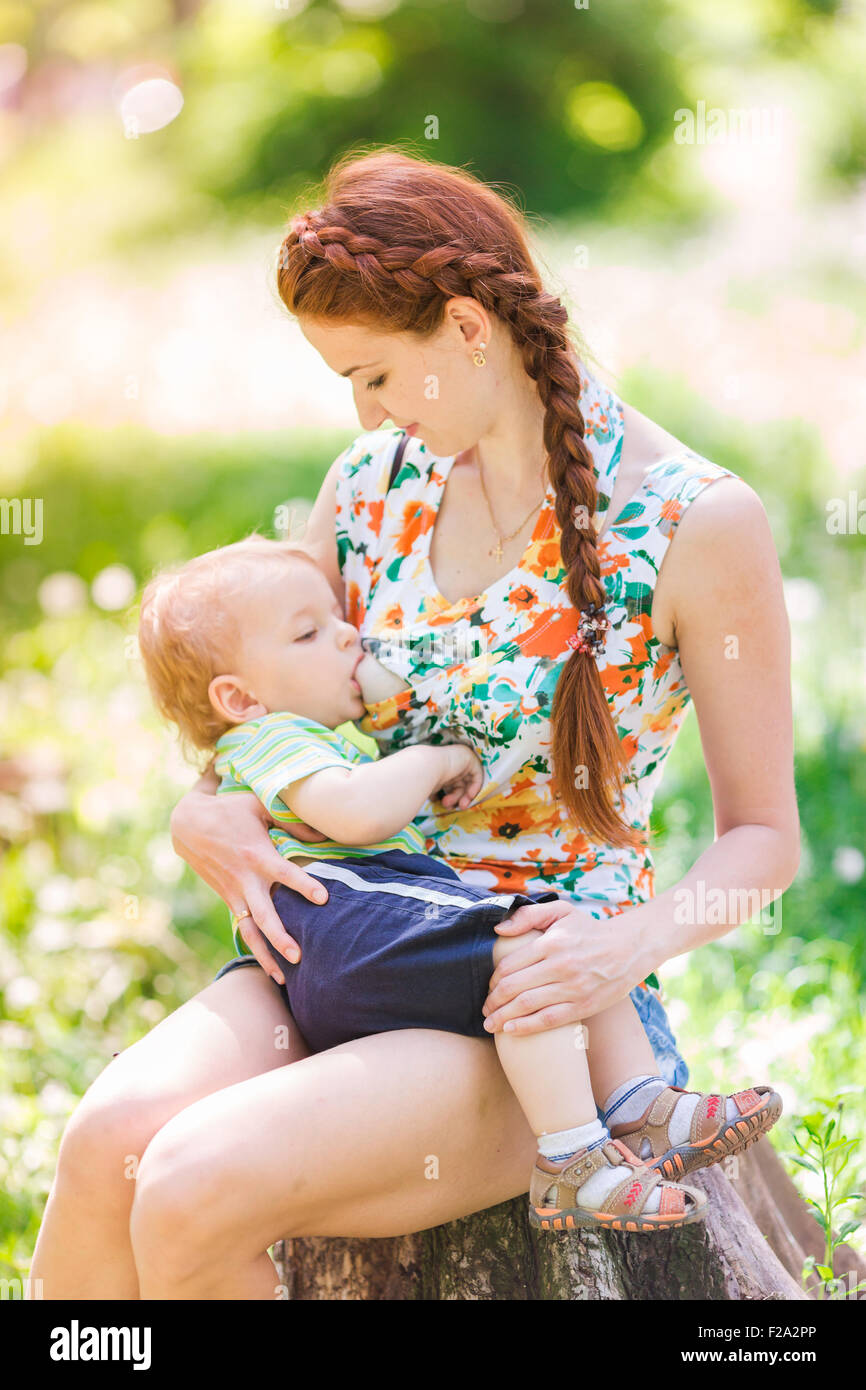 Beautiful happy mother breastfeeding her baby boy outdoor Stock Photo ...