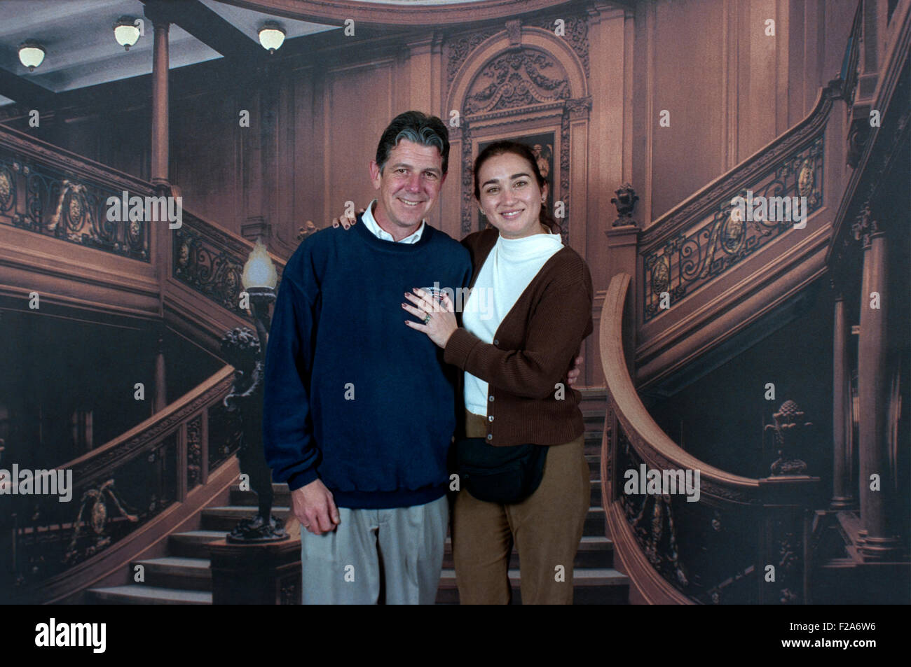 young couple pose in front of titanic grand staircase backdrop on board ...