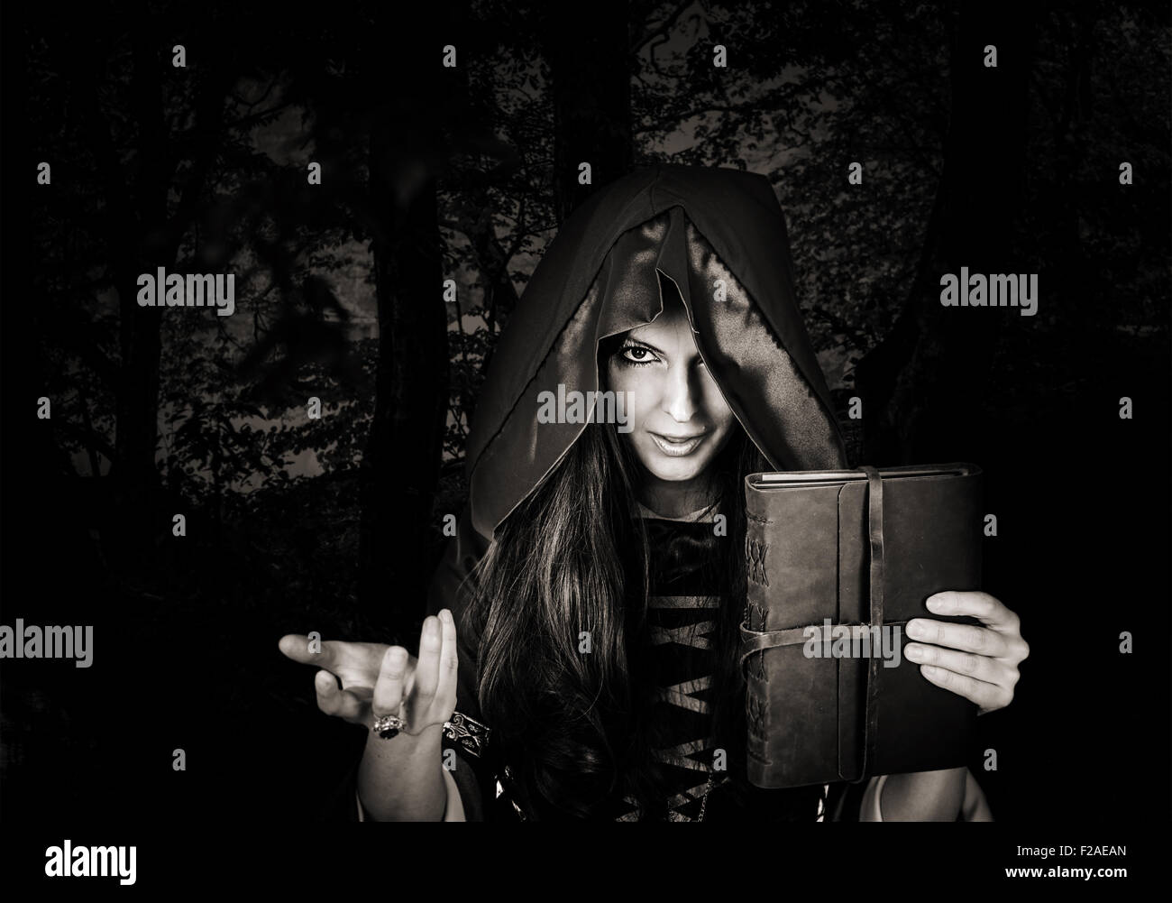 Beautiful young halloween witch wearing vintage gothic dress with hood ...