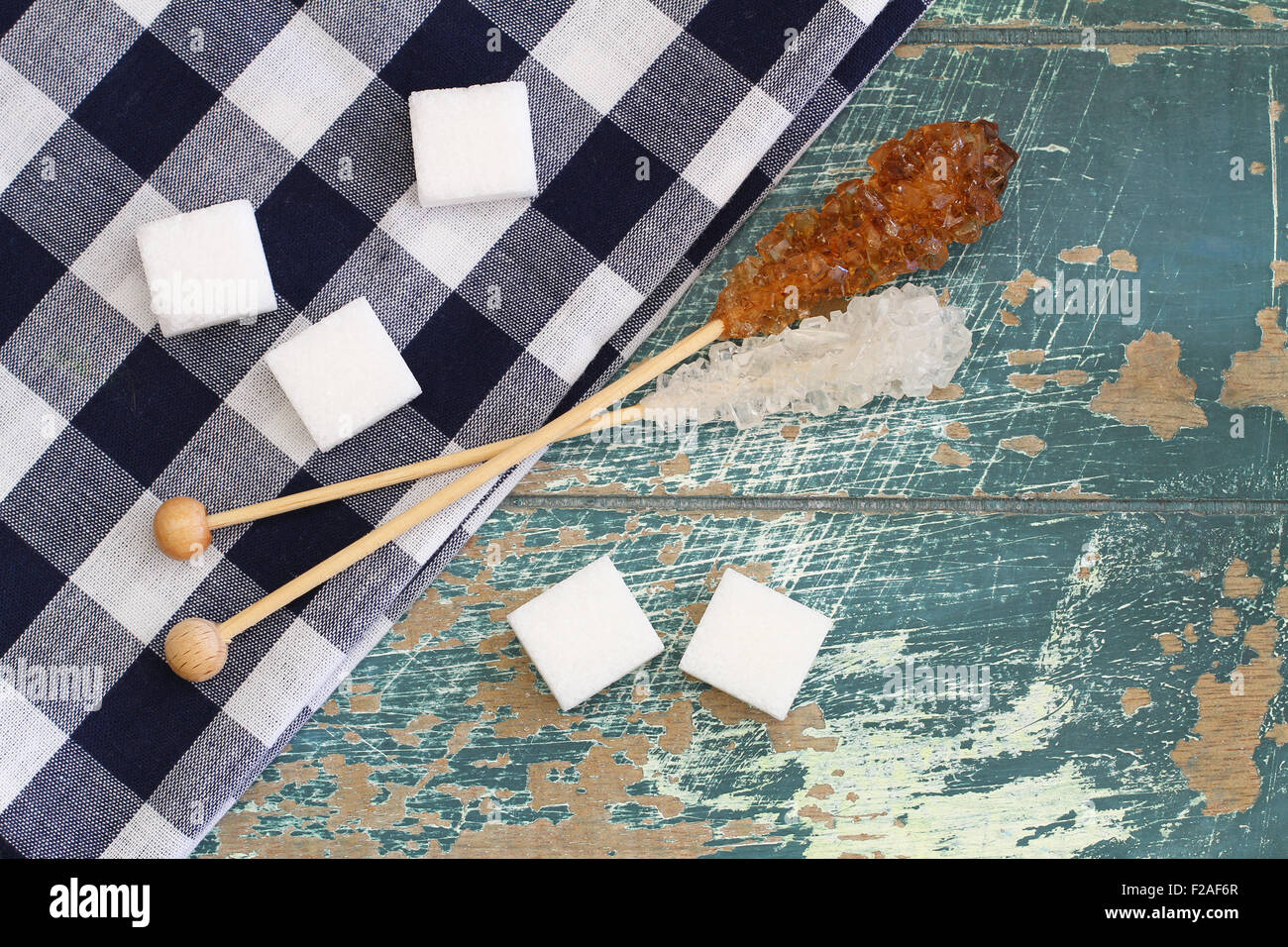 White sugar cubes and white and brown sugar sticks on rustic wooden ...