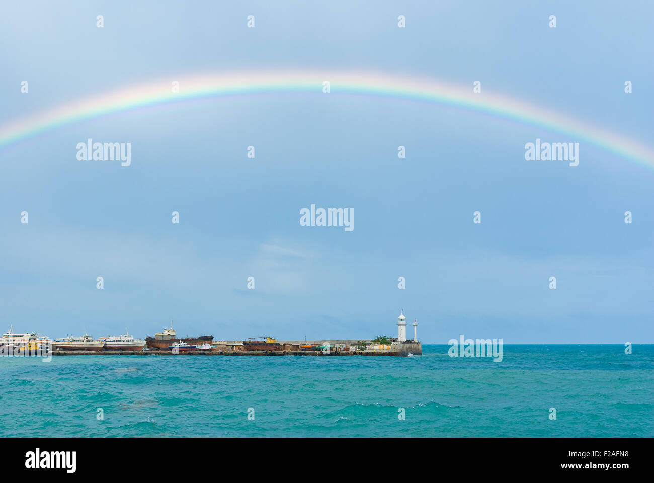 Rainbow over lighthouse in Yalta city in Crimean peninsula Stock Photo ...