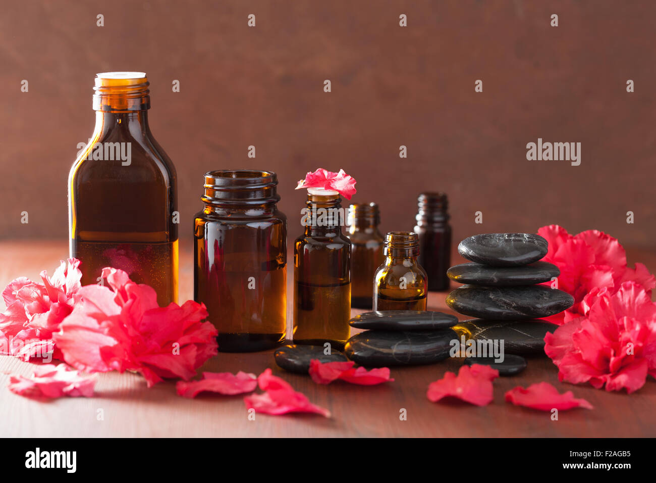 essential oil azalea flowers black massage stones Stock Photo - Alamy