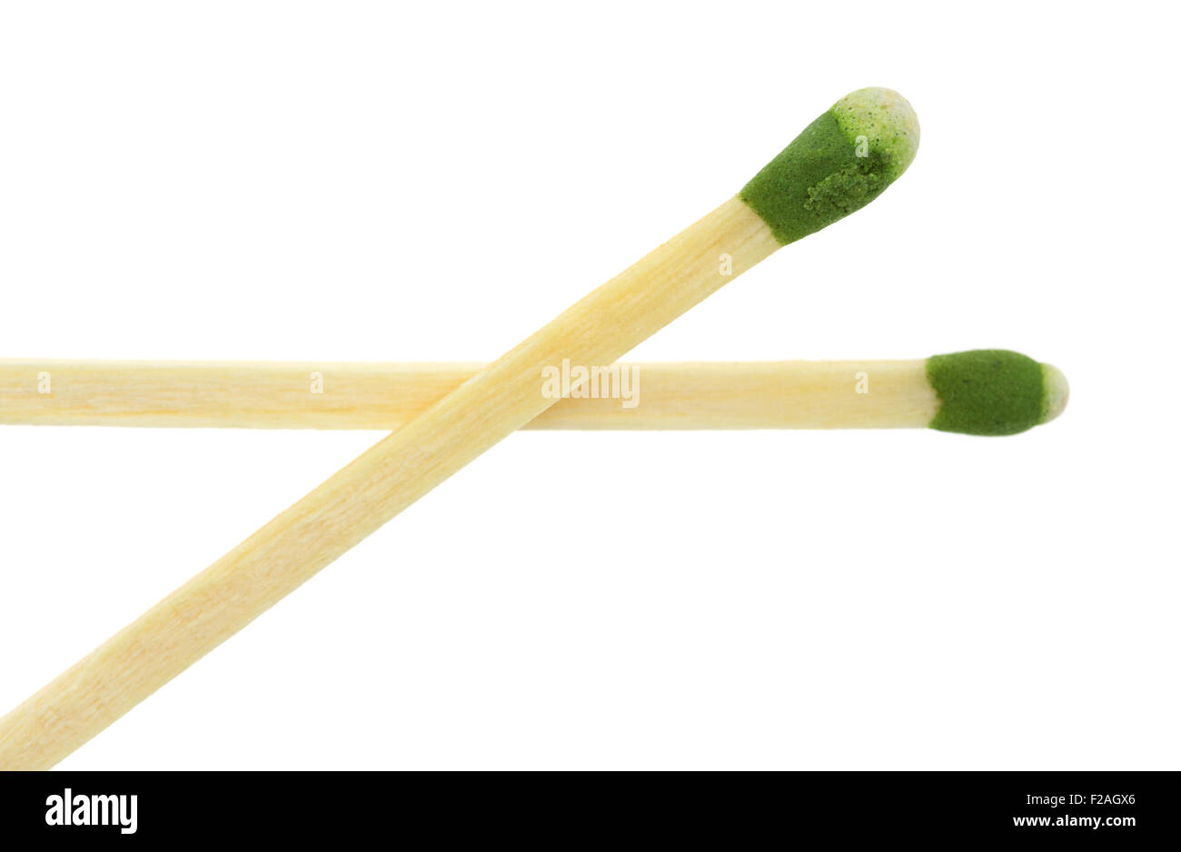 Close view of two green tipped wood large kitchen matches on a white ...