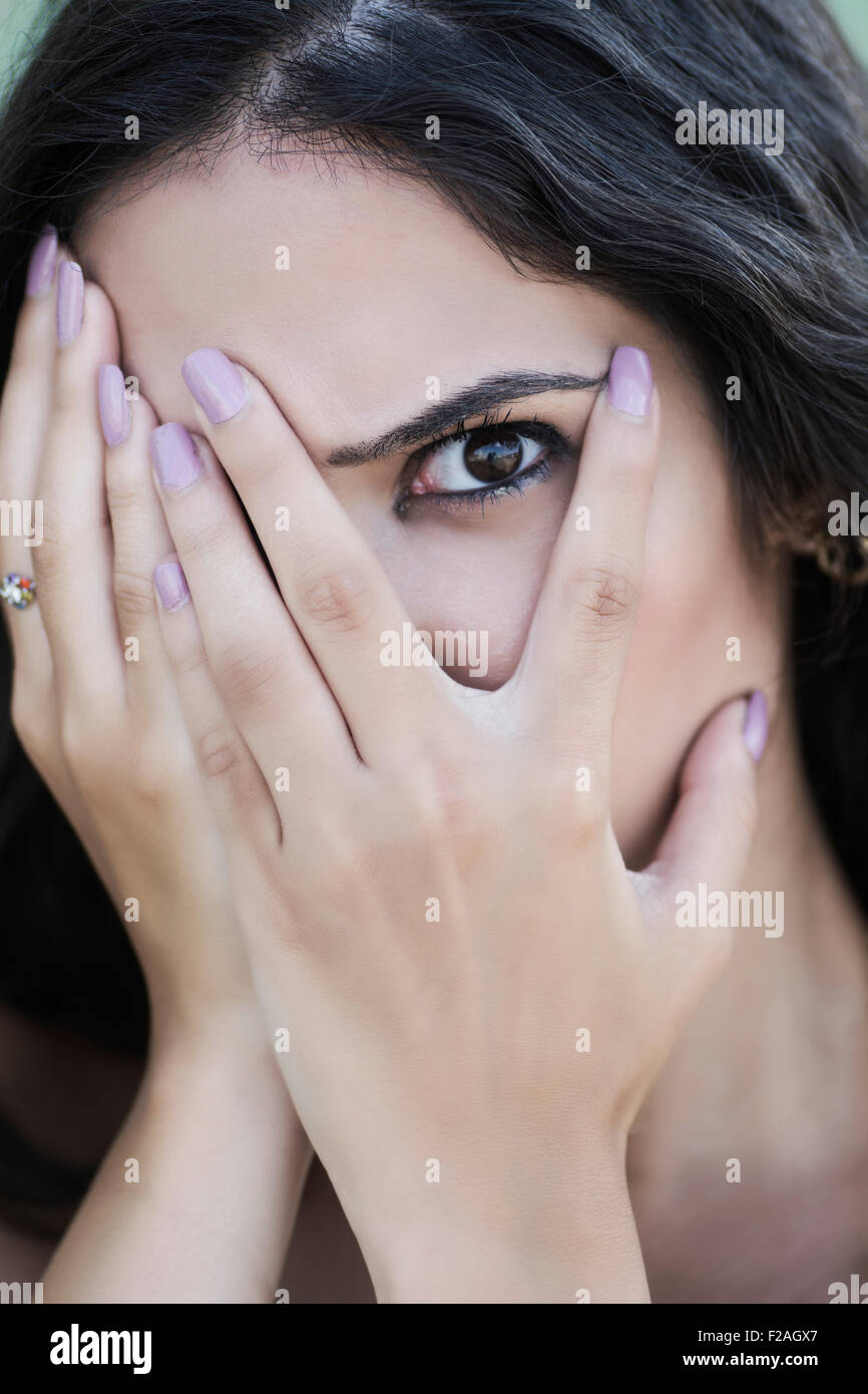 Scared young woman hiding face with hands Stock Photo - Alamy