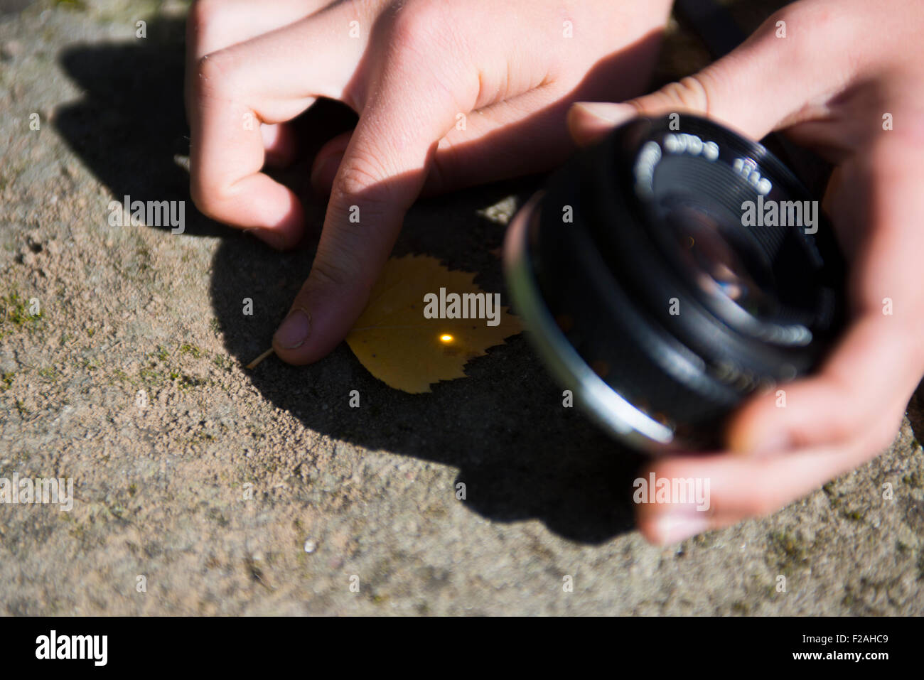 Boy Starting a Fire with a Magnifying Glass Stock Photo - Alamy