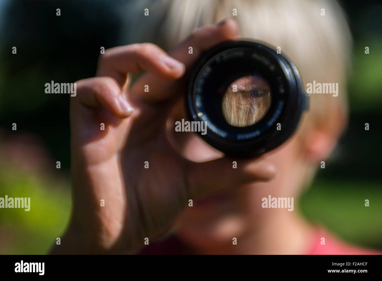 Child boy looking through camera lens Stock Photo - Alamy