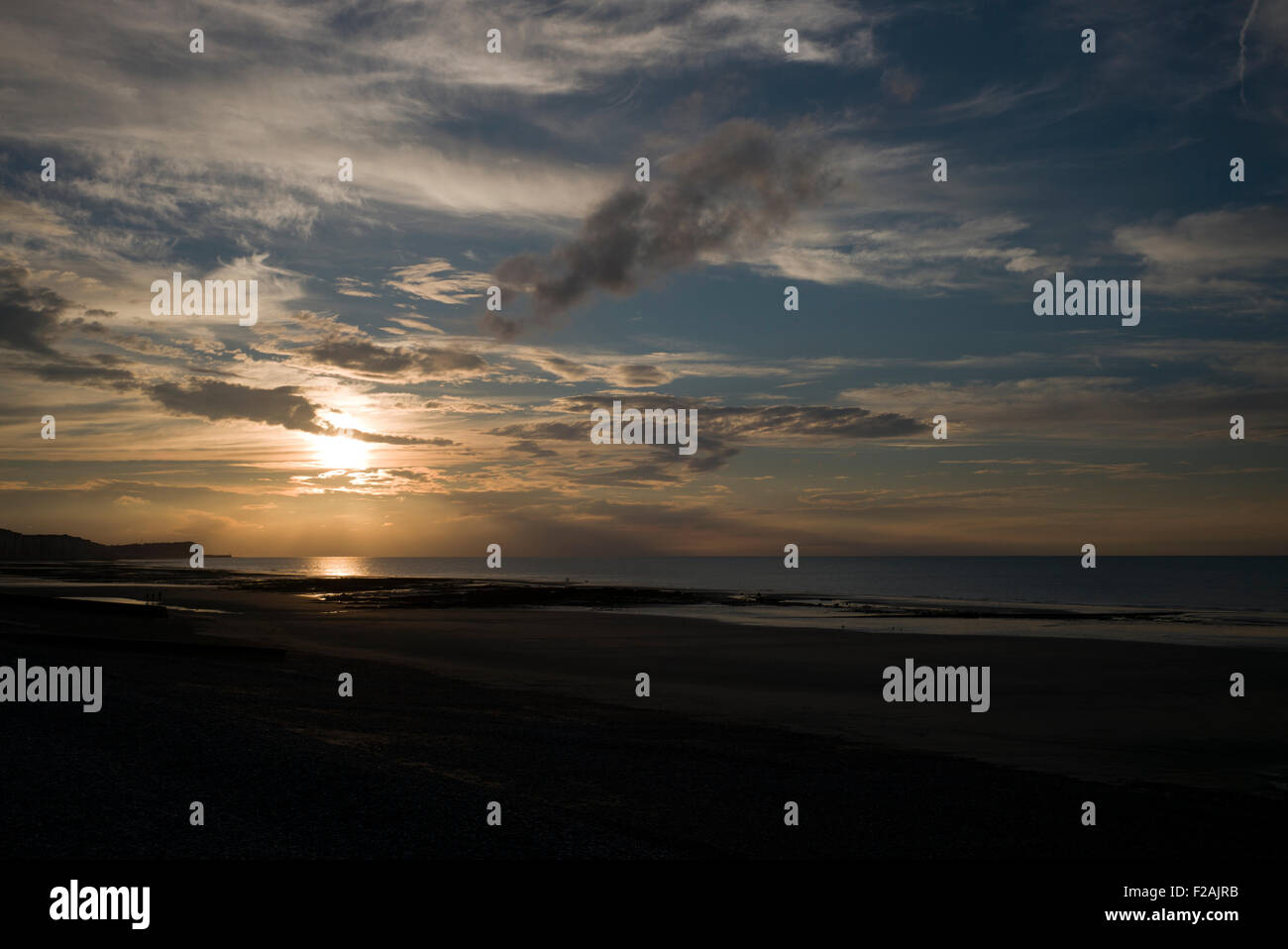 Sunset through clouds over sea and beach, Normandy, France Stock Photo ...