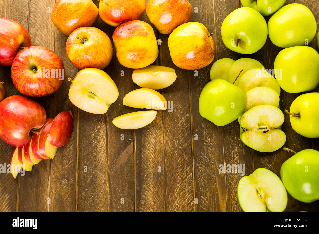 Variety of organic apples sliced on wood table Stock Photo - Alamy