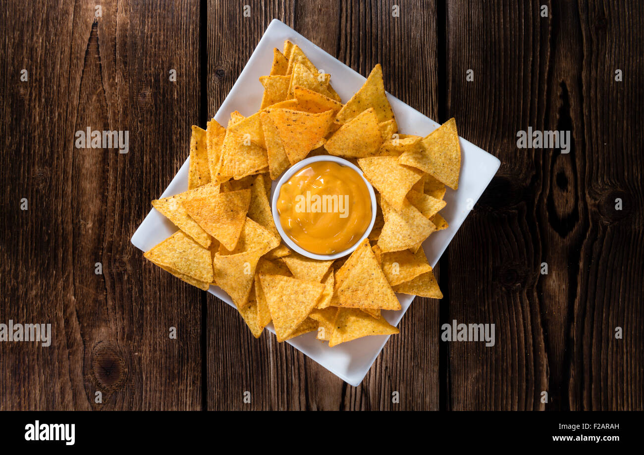 Nachos with Cheese Sauce (close-up shot) on wooden background Stock ...